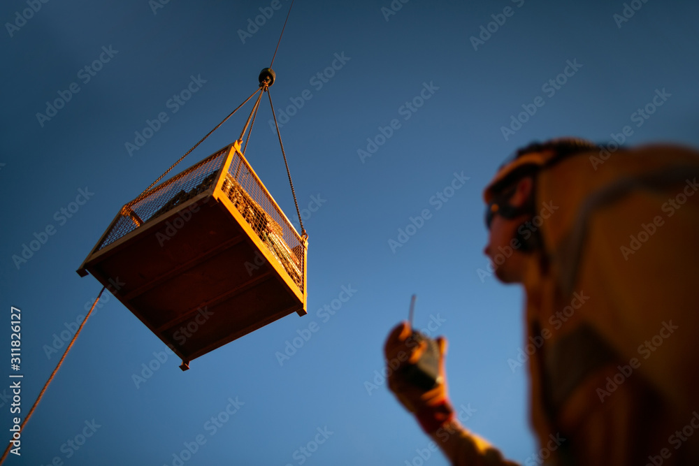 Defocused rigger supervisor holding a 2 ways radio communicated with ...
