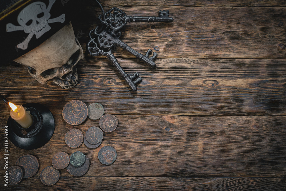 Pirate hat, treasure coins and keys from old chest on the wooden desk ...