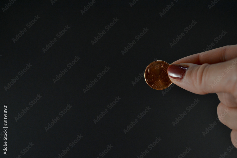 Women hand showing coin on black background Stock Photo | Adobe Stock