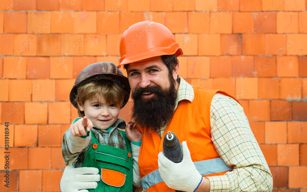 Fotka „Best team ever. Happy father and son build their house together ...