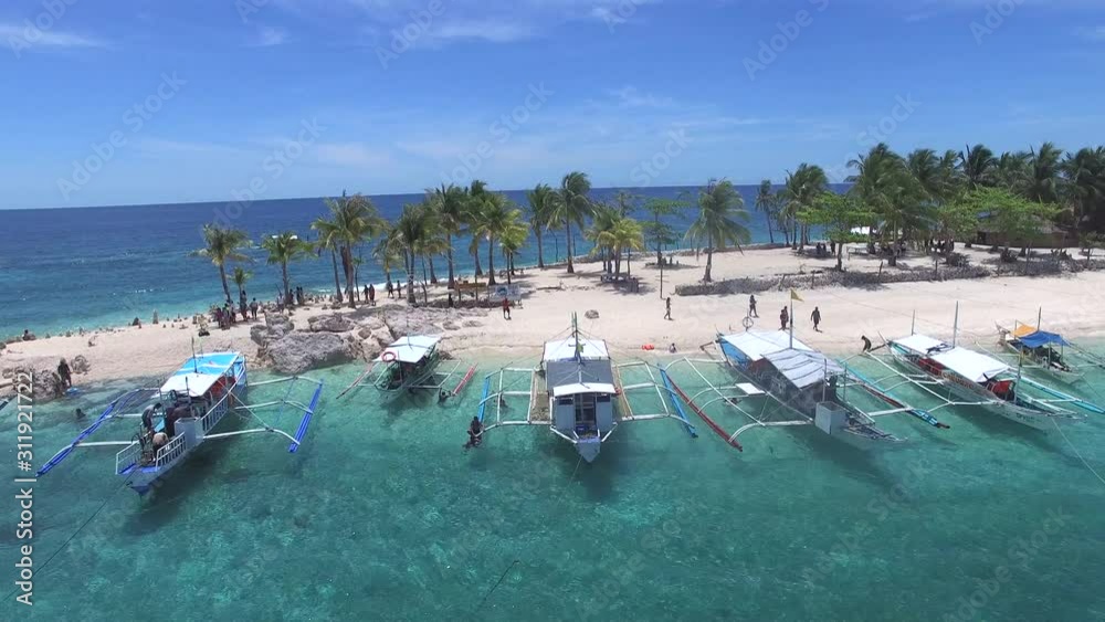 A row of traditional Filipino wooden bamboo outrigger native pontoon ...