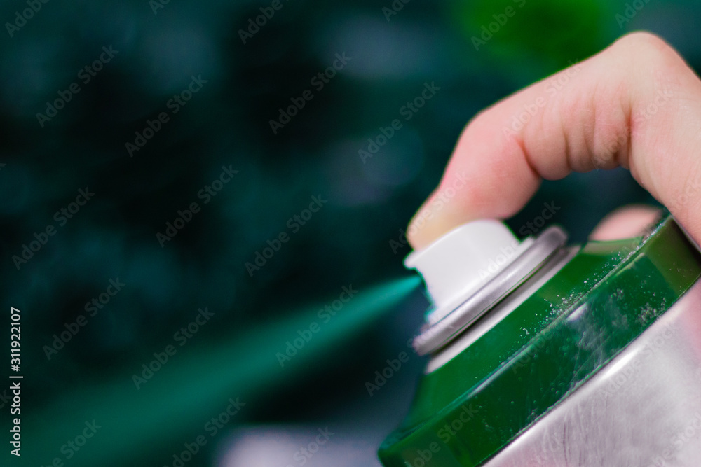 Green spray paint. Green spray from a spray can. Blurred turquoise ...