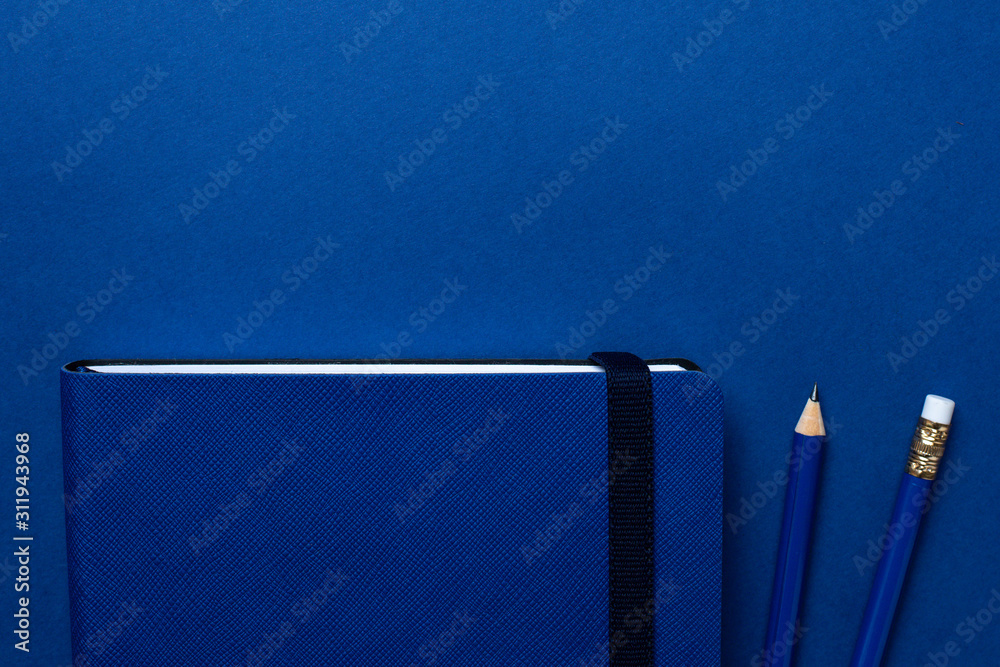 Blue office notebook and pencil on a classic blue background. Trendy ...