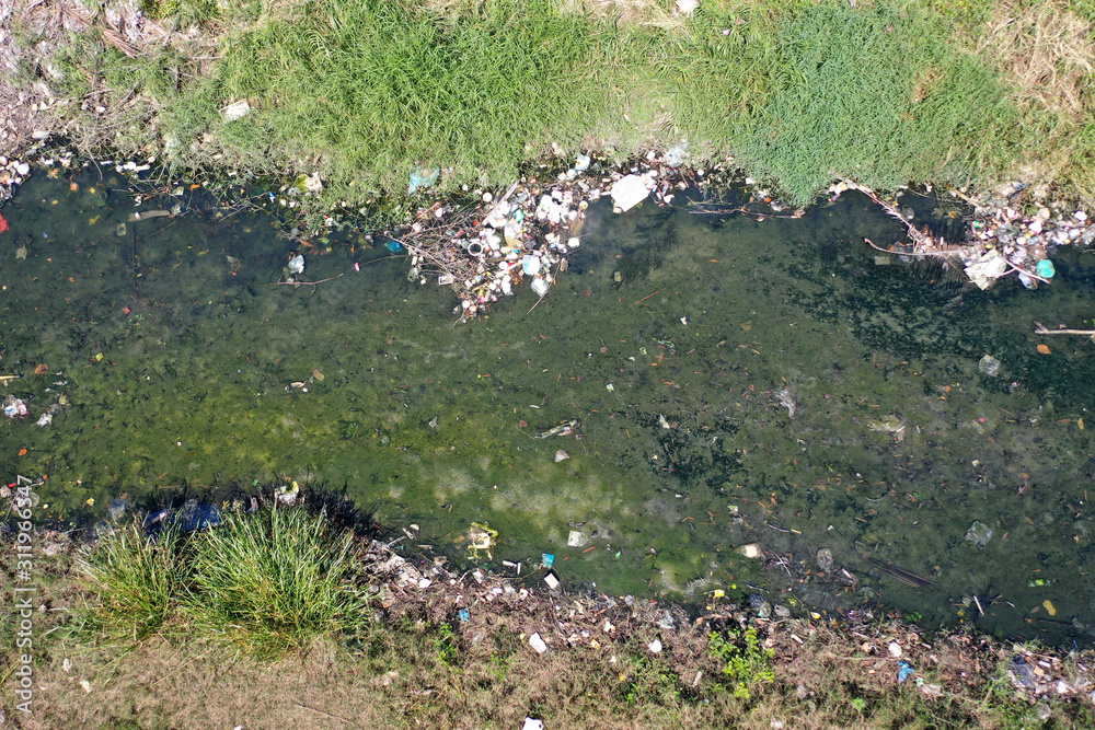 Water pollution. Raw sewage and plastic trash dumped in stream in poor ...