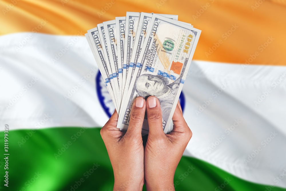 India financial concept. Female hand holding dollar banknotes on ...