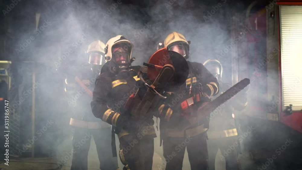 group of firefighters wearing full equipment, oxygen masks, and ...