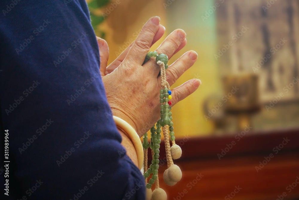 Woman press the hands together at the chest in sign of respect and hold ...