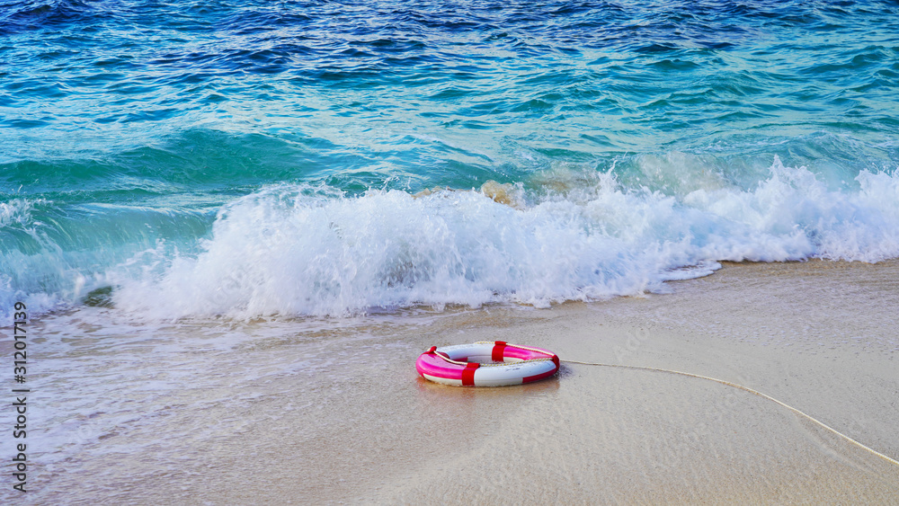 Bright life-saving red-white lifebuoy in the sea floats on the blue ...