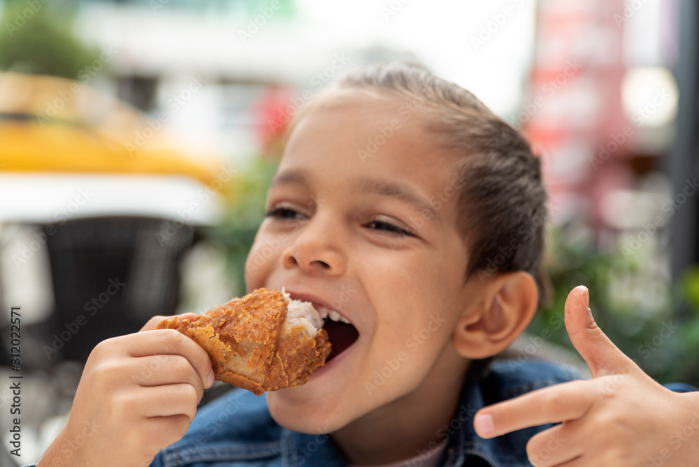 little boy eats fried chicken Stock Photo | Adobe Stock