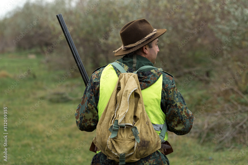Hunting period, autumn season open. A hunter with a gun in his hands in ...