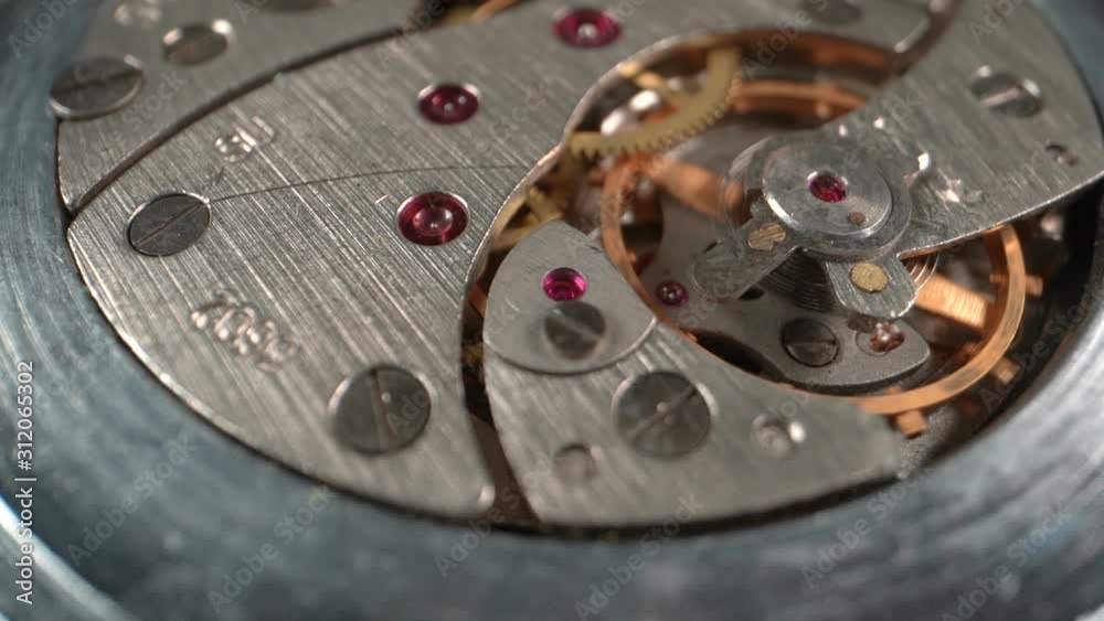 The interiors of an old working mechanical watch with rotating gears ...