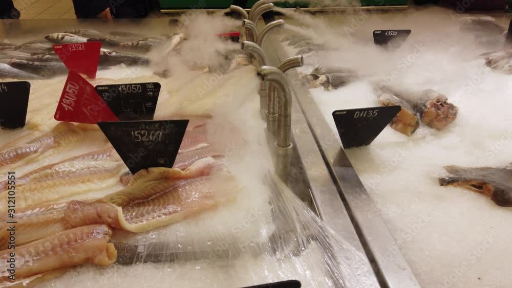 Fresh fish is cooled on the supermarket counter. Fresh raw fish on ...