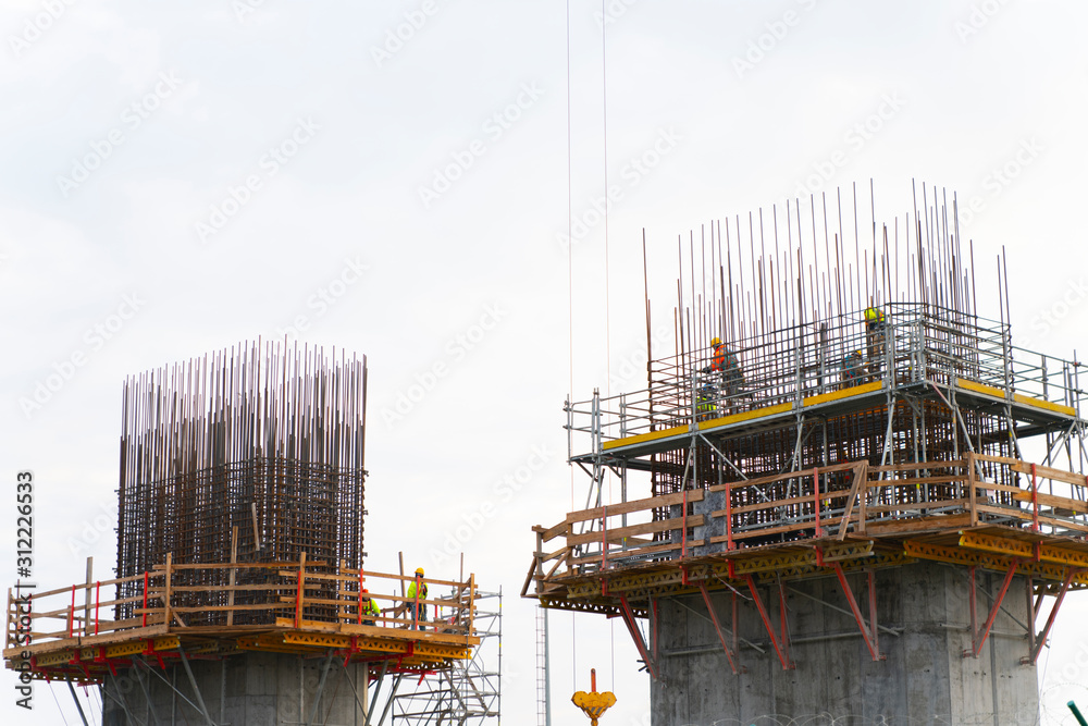 Bridge widening construction project: Workmen ties reinforcing bars in ...