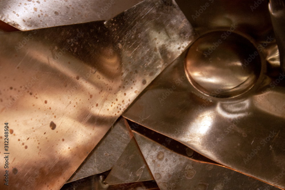 Curved pieces of copper sheets of various shapes. Glare on sheets of ...