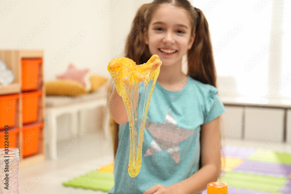 Preteen girl with slime in playroom, focus on hand Stock Photo | Adobe ...
