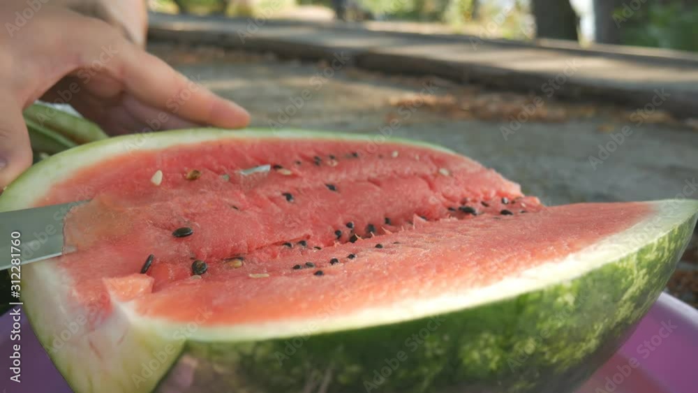 Process of tasting of watermelon. Knife cuts flesh and hand takes it to ...