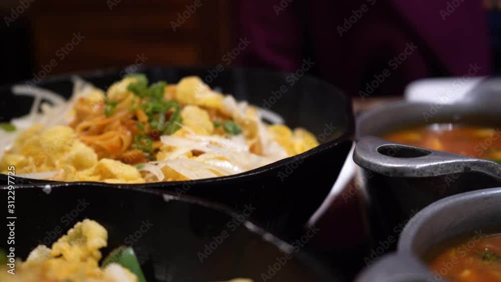 Push in shot of khow suey noodles gravy and fried nuts, onions placed ...