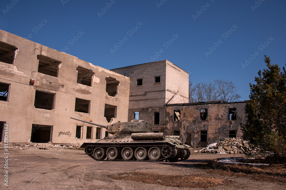 A war scene of a tank preparing to shoot at a demolished stone building ...