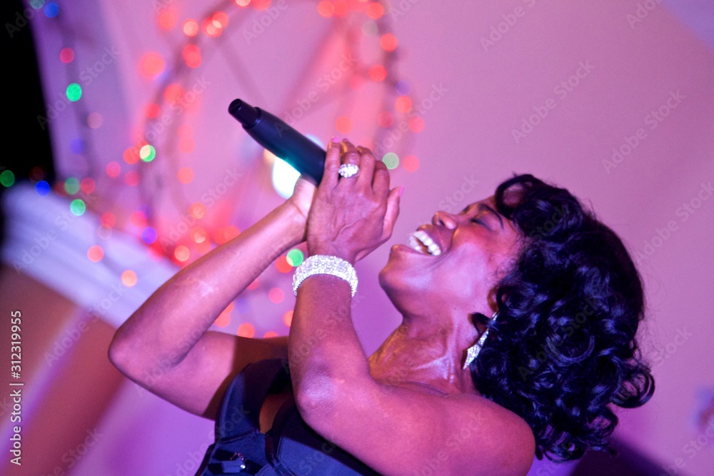 beautiful African singer woman singing with colorful lights background ...