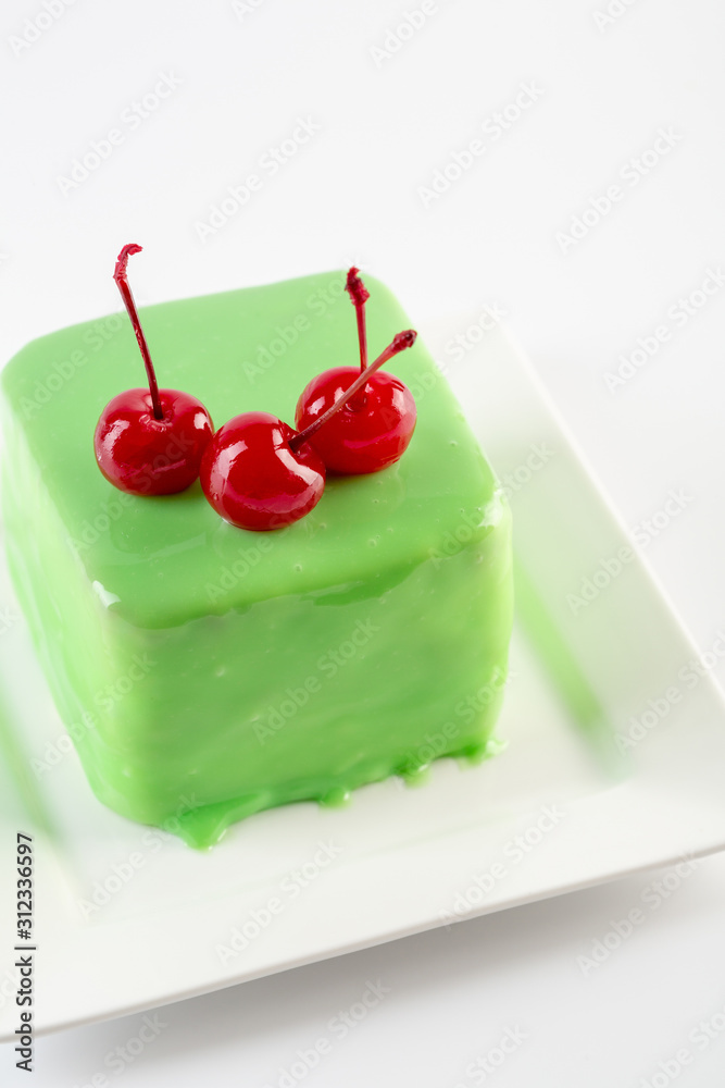 Green mousse cake with chery on plate Stock Photo | Adobe Stock