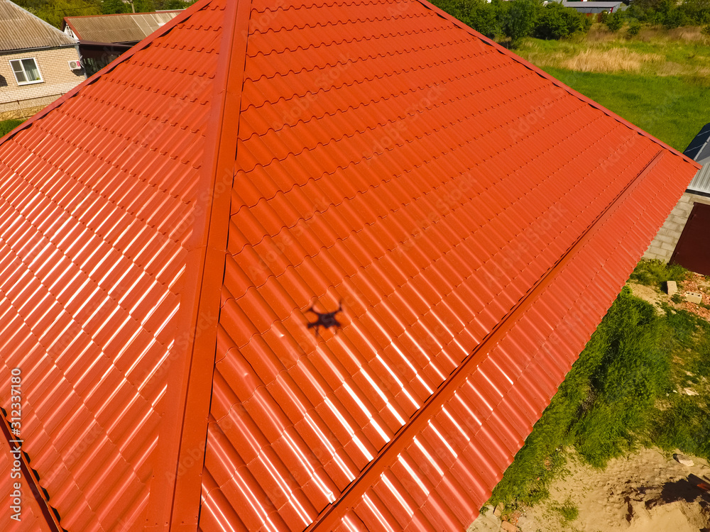 House with an orange roof made of metal, top view. Metallic profile ...