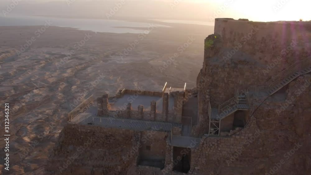 Aerial drone shot, flying over and tracking the ruins of the Masada ...