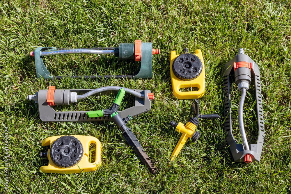 Various types of the garden sprinklers on the mown lawn in the summer ...