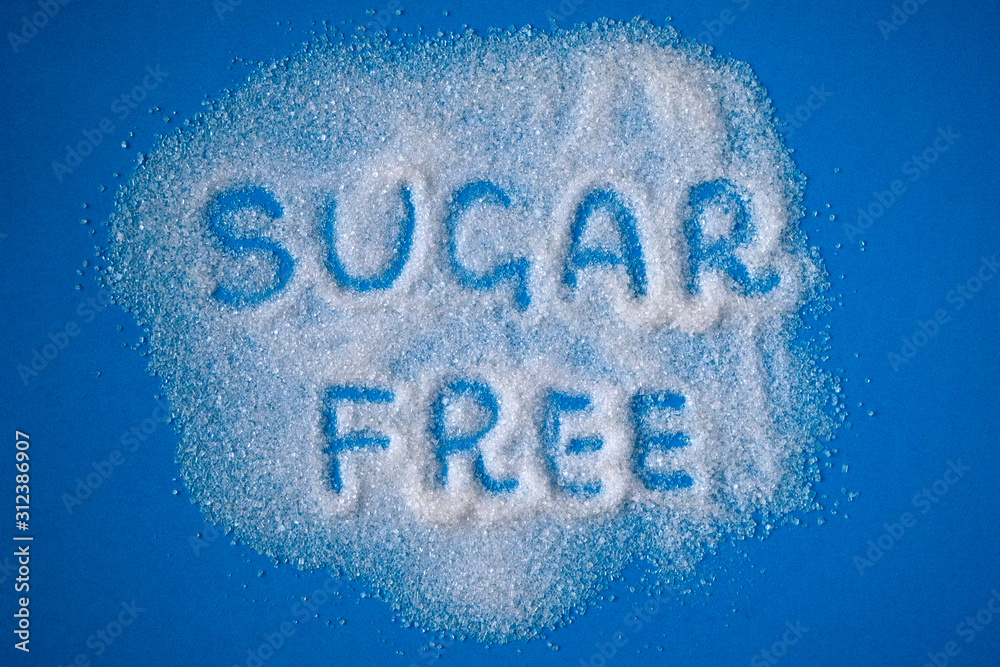 Sugar Free words hand written on a heap of white sugar on a blue ...