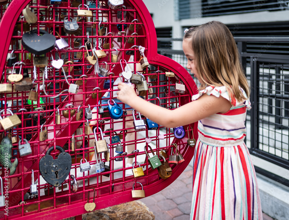 Young Girl looking at the love locks in Florida, eye-level, side view ...