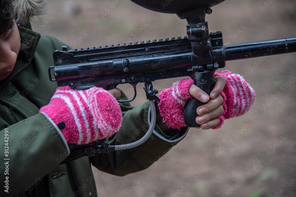 boy with green jacket playing gotcha in the woods among trees Stock ...