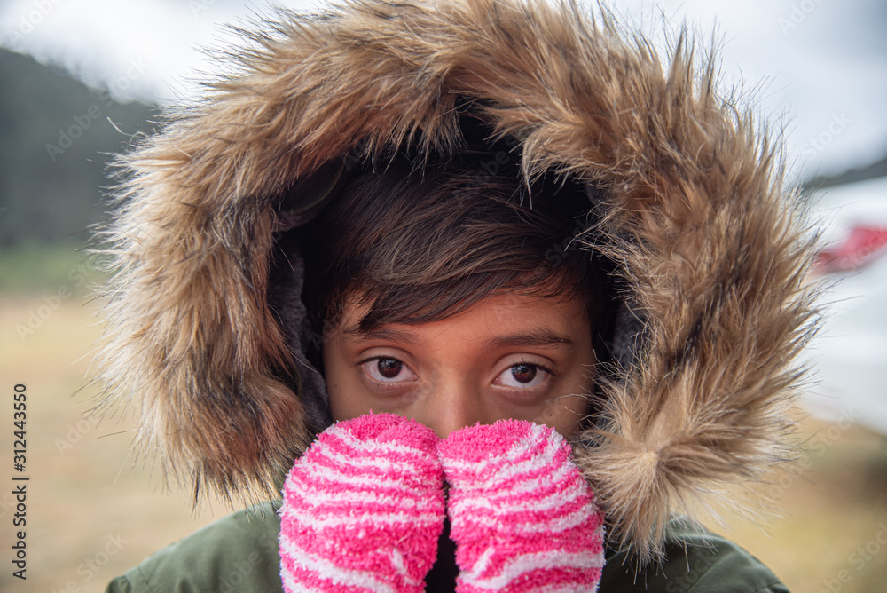 big-eyed boy with winter jacket and gloves in the forest Stock Photo ...