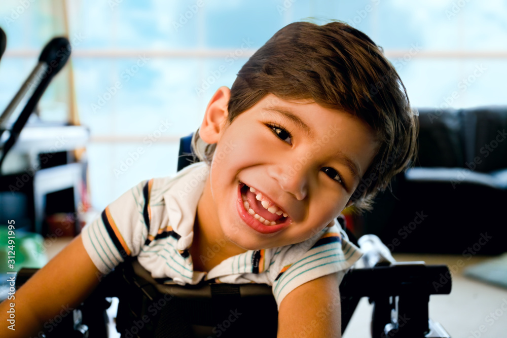 Foto de Happy smiling biracial disabled little boy standing in walker ...