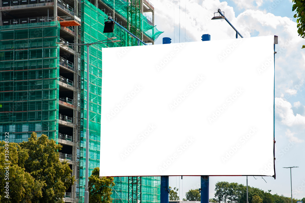 Advertising billboard mockup in front of construction site of modern ...