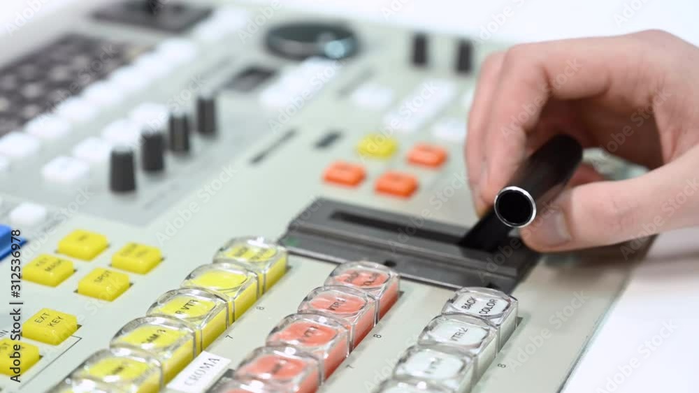 Producer is touching and pressing keys in a control panel of tv and ...