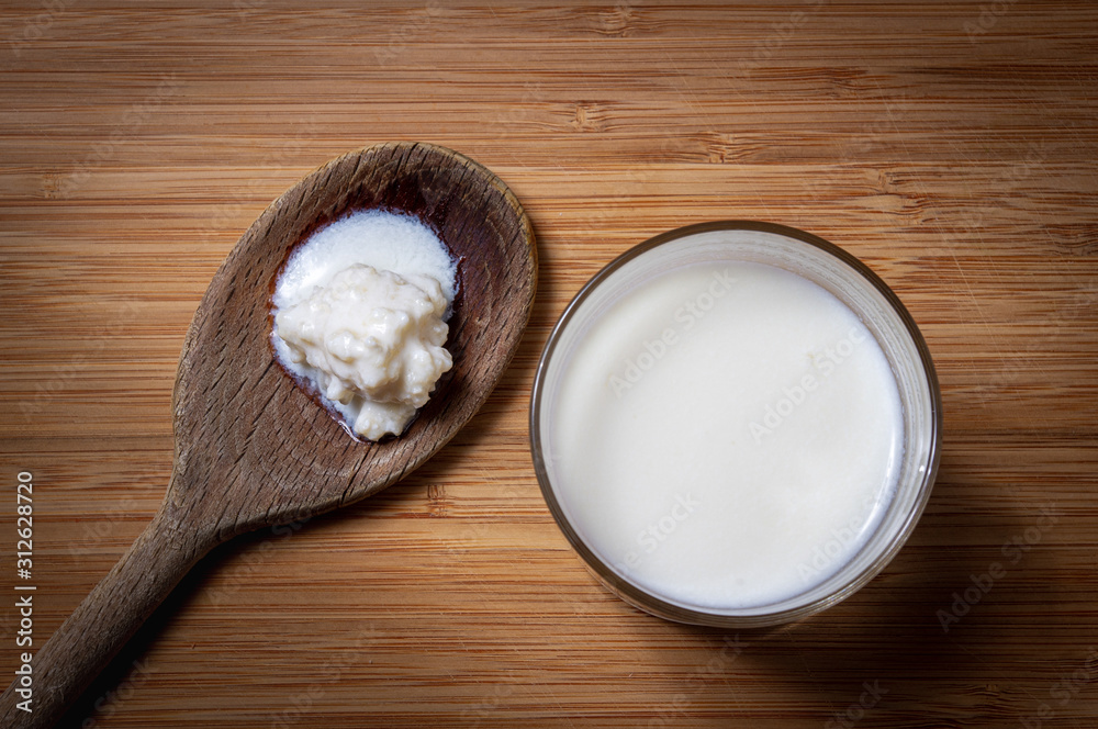Milk Kefir grains on a wooden spoon and a glass of Kefir milk Stock ...