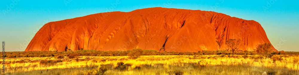 Banner panorama of red color of Uluru or Ayers Rock at sunset, the huge ...