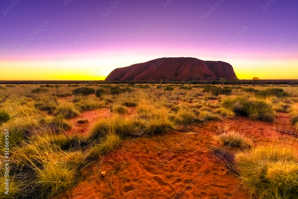 Dramatic dawn sky behind monolith Ayers Rock. Colors of sky at Uluru at ...