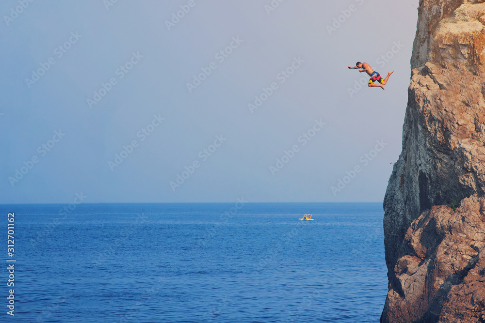 Person Jumping Off Cliff Into Water