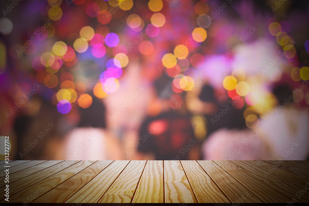 Empty wooden table with abstract blurred colorful neon light party ...