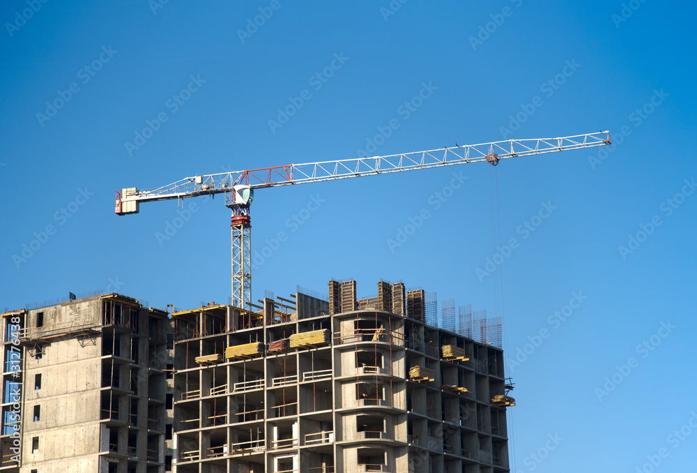 Hydraulic luffing jib tower cranes and workers being poured concrete ...