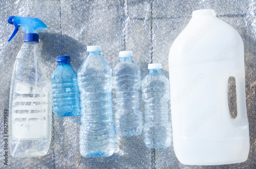 plastic bottles in blue and transparent colors being recycled for an ...