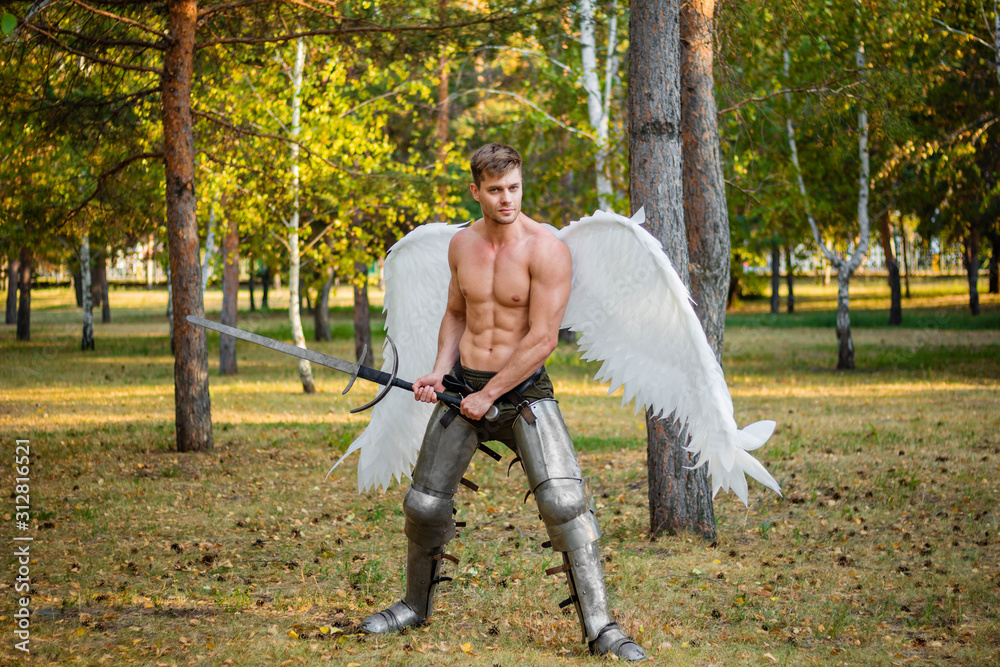 A young angel, a bodybuilder in plate armor on his legs with wings ...