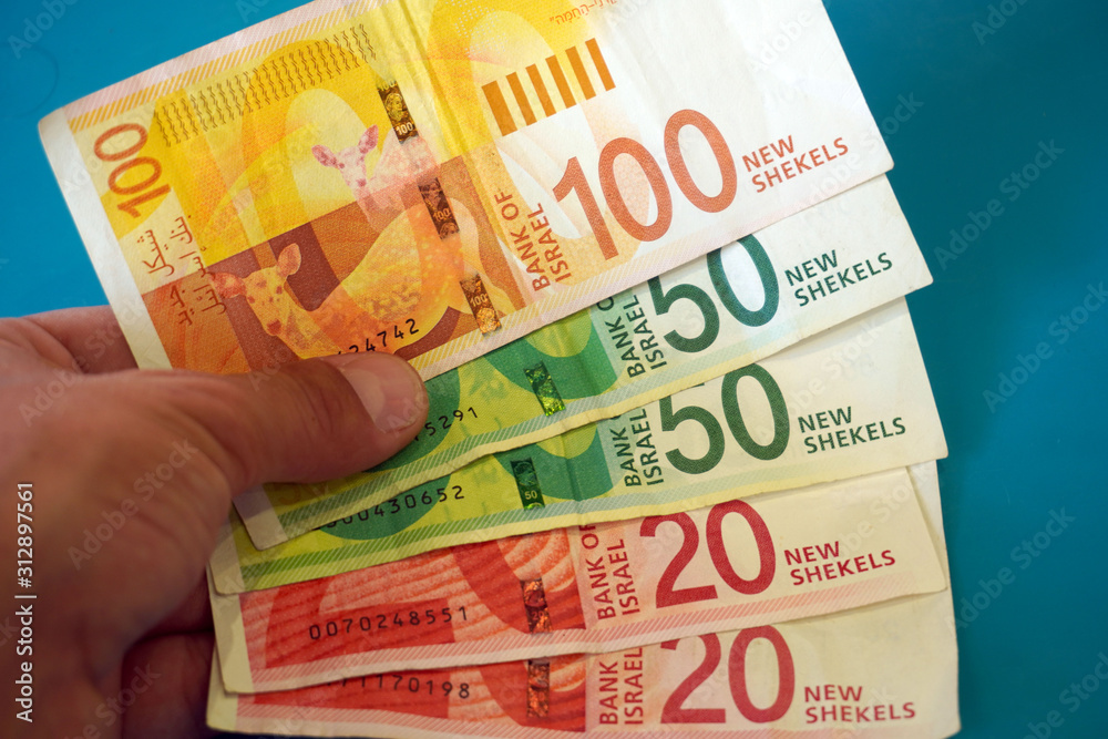Pile of NIS - New Israeli Shekels banknotes with the new 200, 100, 20 ...
