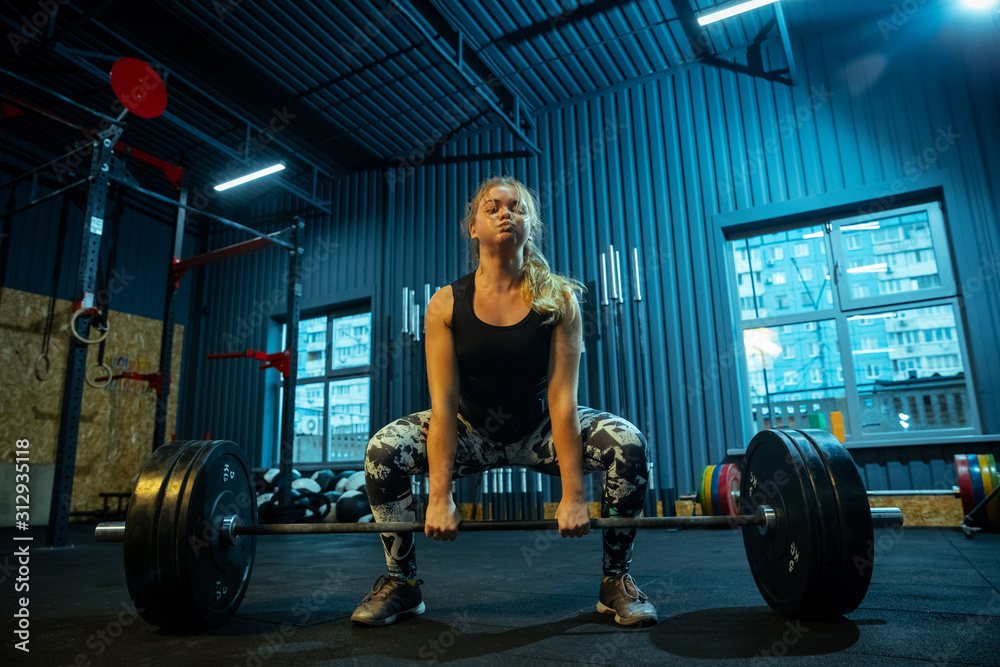 Caucasian teenage girl practicing in weightlifting in gym. Female ...