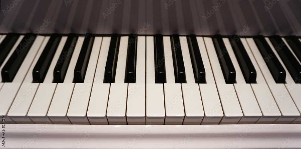 Piano black and white keys of a concert grand piano are reflected in ...