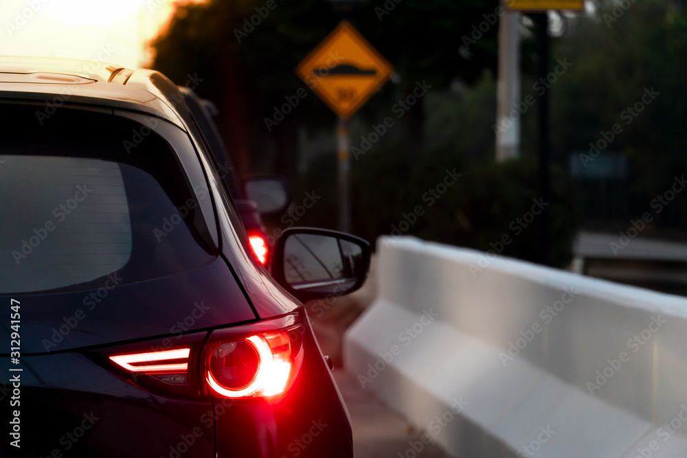 Brake light of cars on the road with wall of bride white color beside ...
