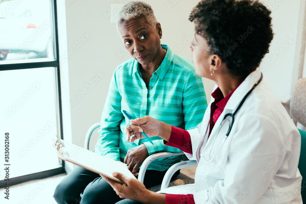 Patient reviewing chart with doctor Stock Photo | Adobe Stock