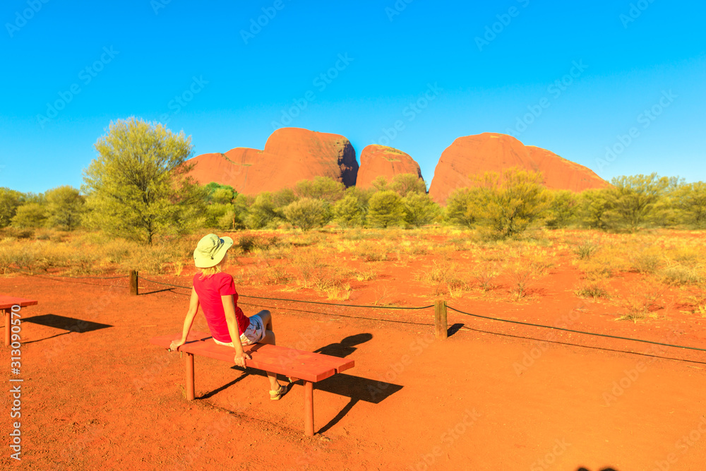 Tourist woman relaxing on a bench in Uluru-Kata Tjuta National Park ...