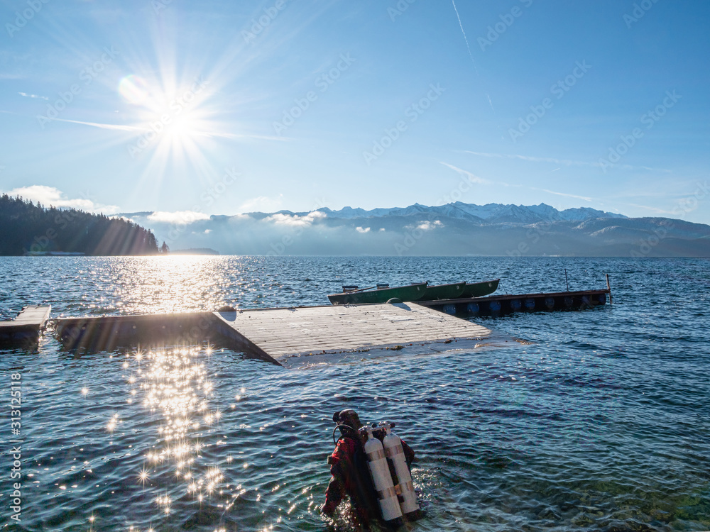 Walchensee in Bavaria with view to sun and Pier during ice cold winter ...