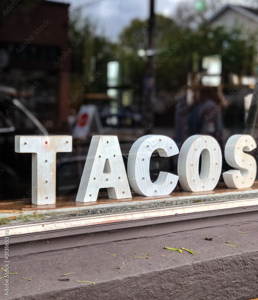 Tacos sign seen inside a restaurant window Stock Photo | Adobe Stock
